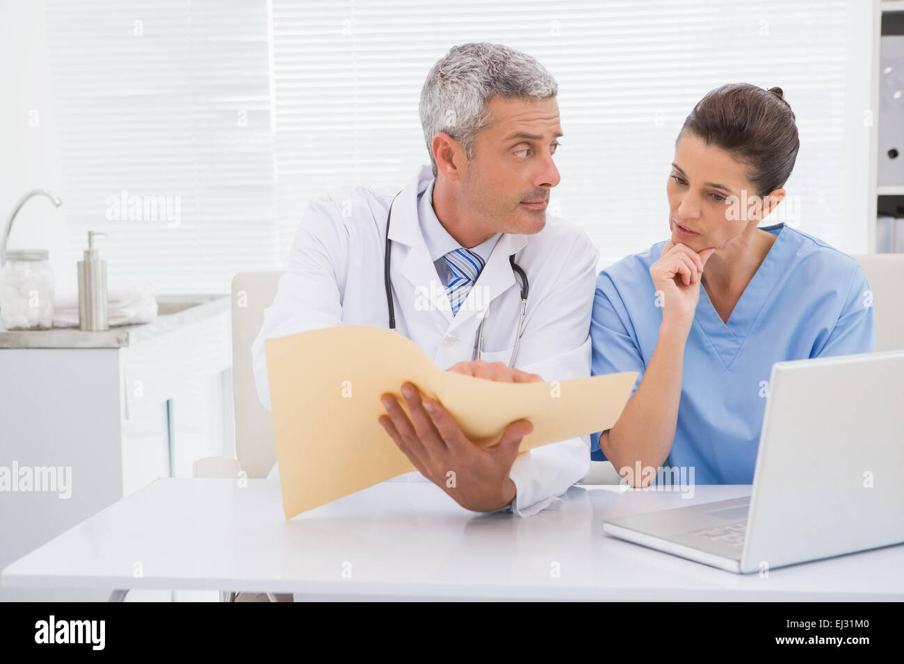 Doctors looking at files Stock Photo - Alamy