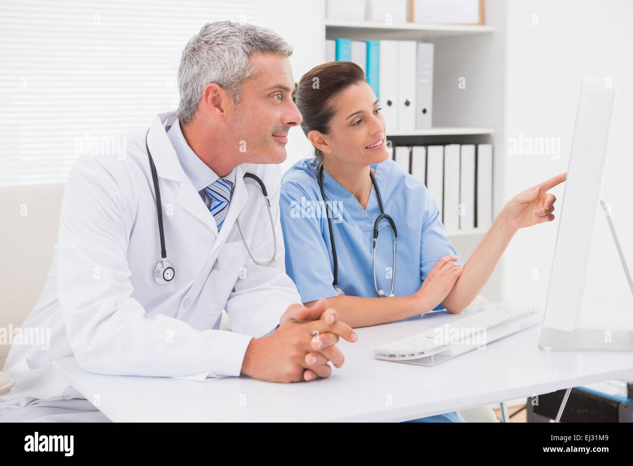 Doctors looking at computer Stock Photo - Alamy