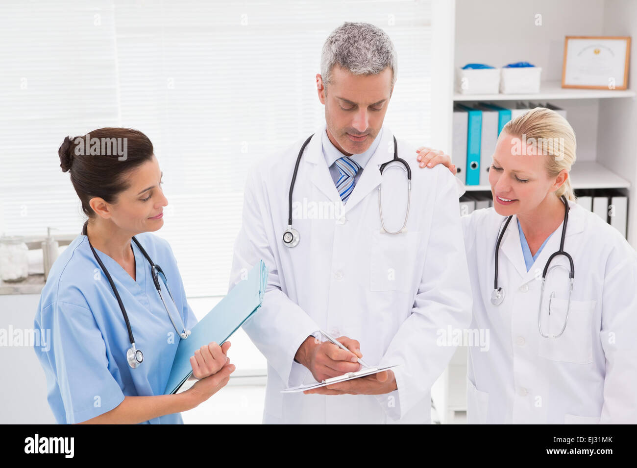 Doctors looking at clipboard Stock Photo - Alamy