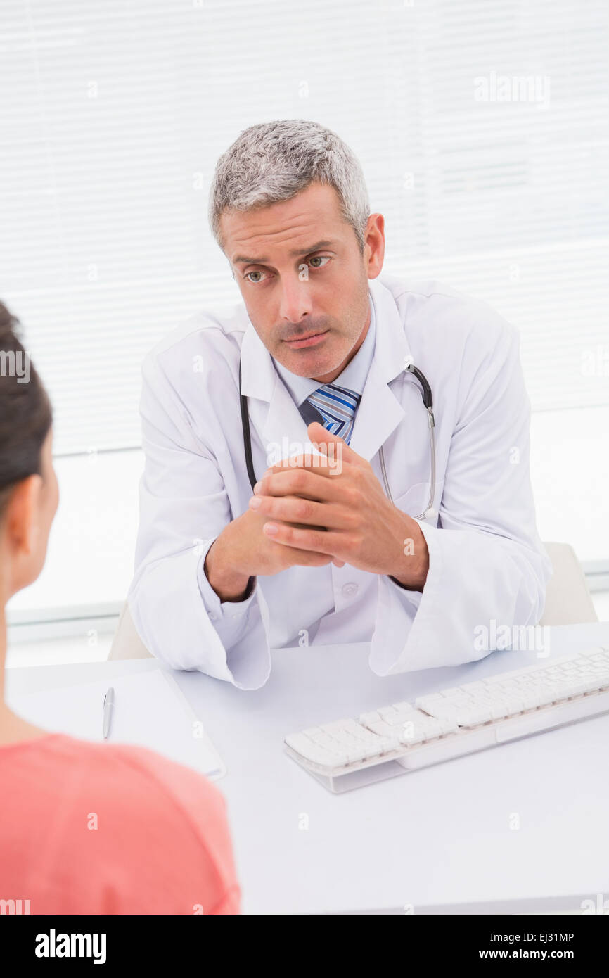 Patient consulting a serious doctor Stock Photo - Alamy