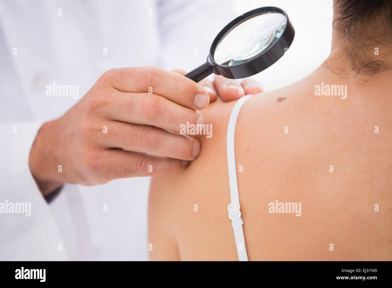 Doctor examining patient with magnifying glass Stock Photo - Alamy