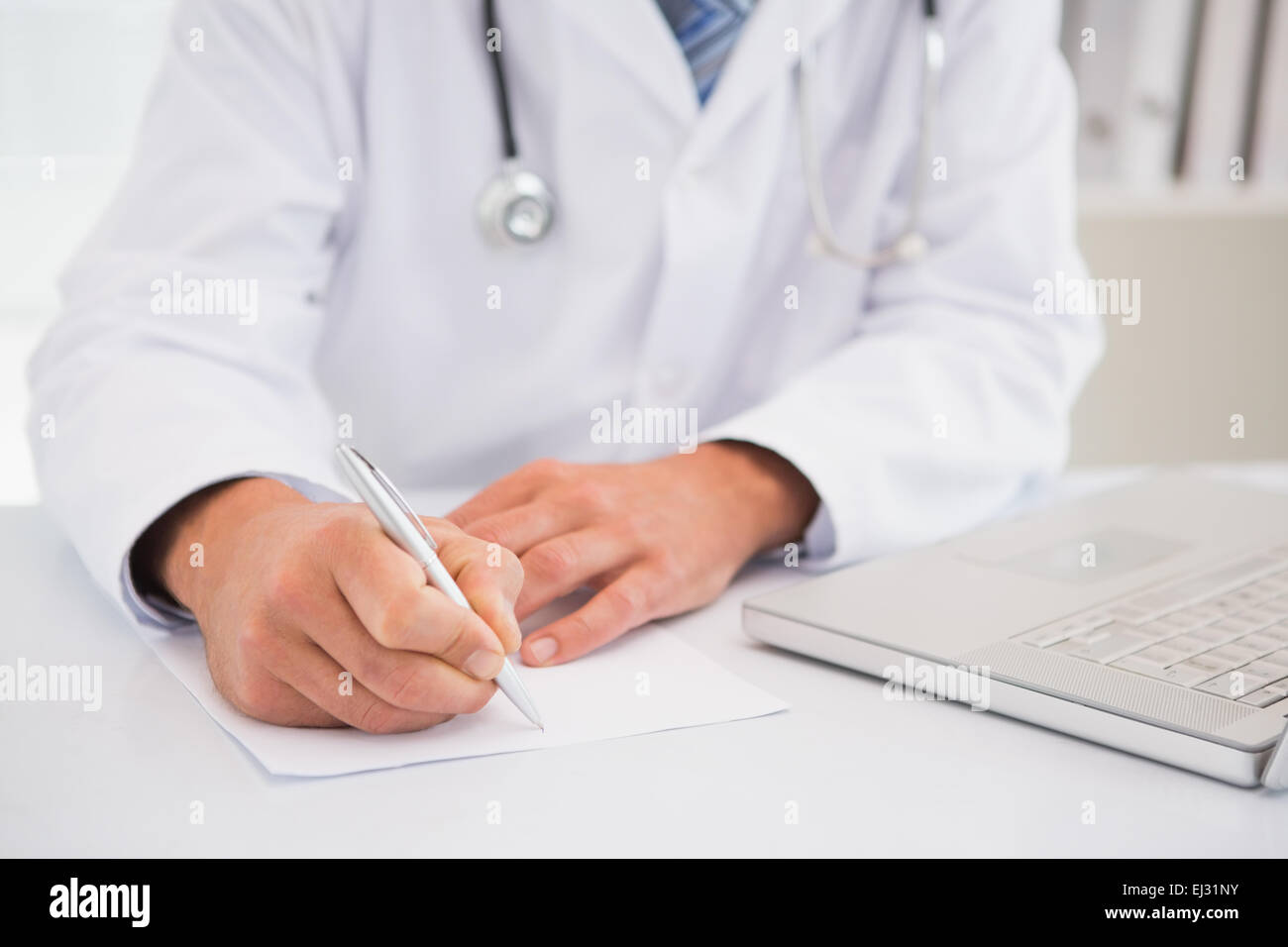 Doctor writing on a notepad Stock Photo - Alamy