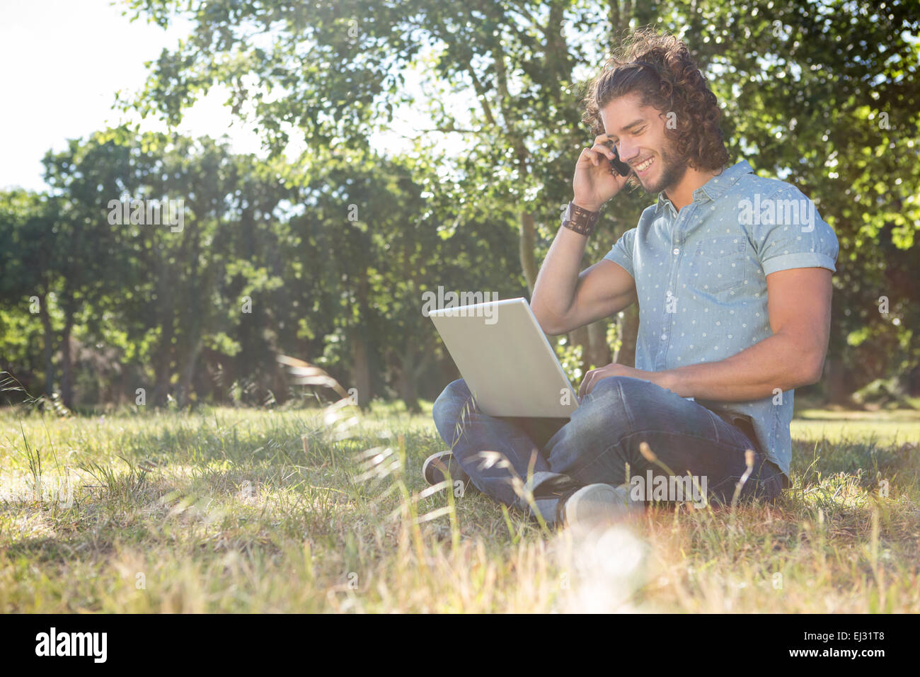 Young man using laptop in the park Stock Photo - Alamy