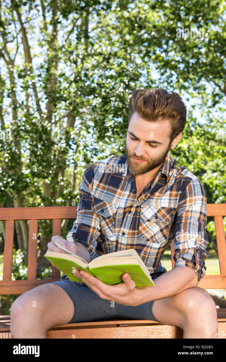 Handsome hipster reading in the park Stock Photo - Alamy