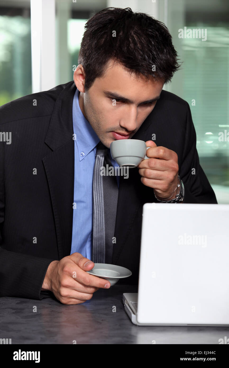 Man with computer and coffee cup Stock Photo - Alamy
