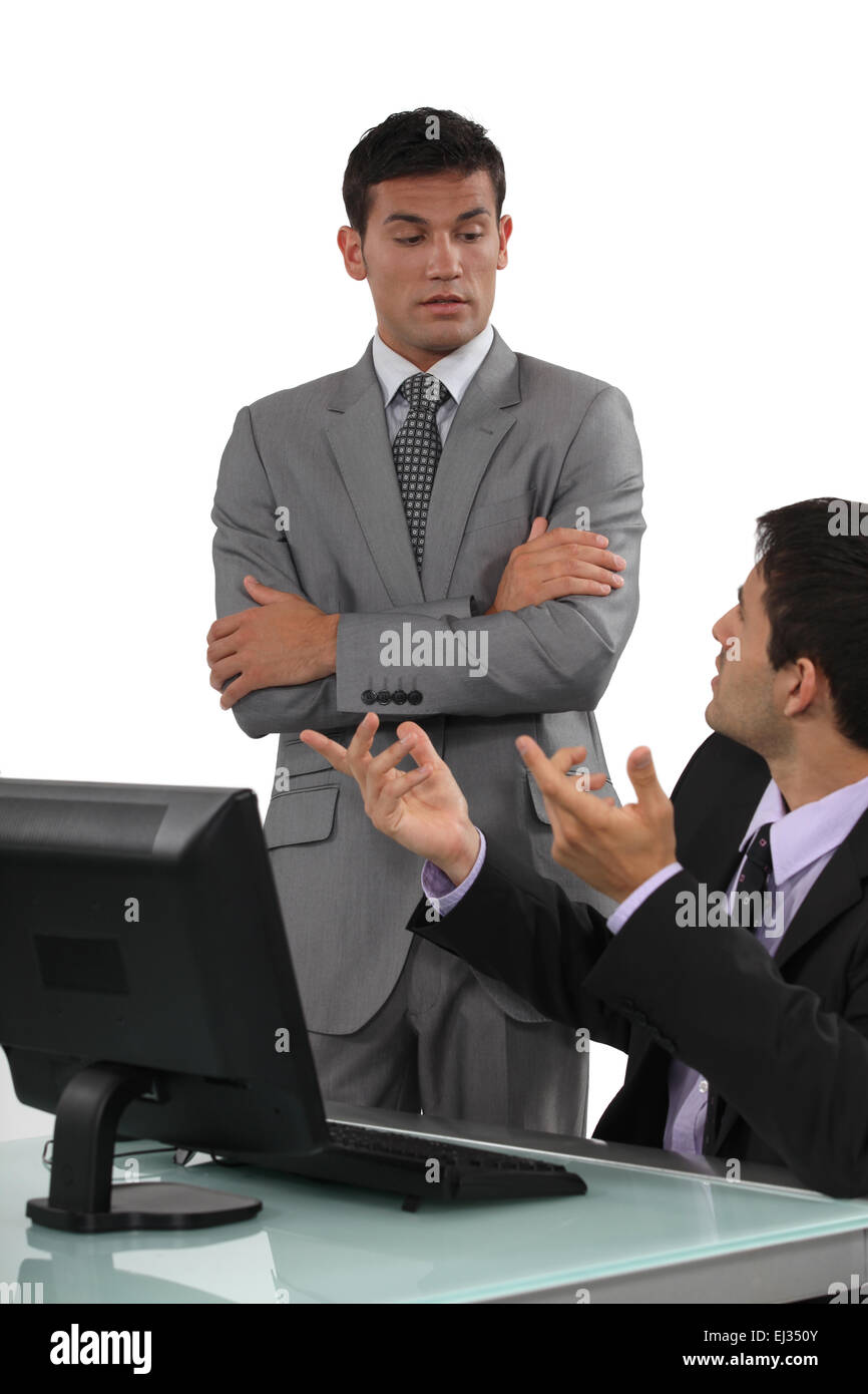Boss having a discussion with his defensive employee Stock Photo - Alamy