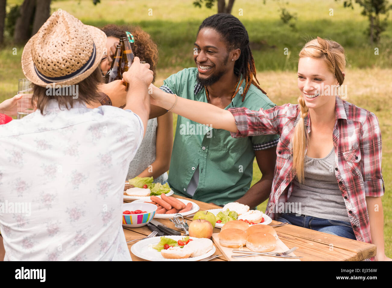 Happy friends in the park having lunch Stock Photo - Alamy