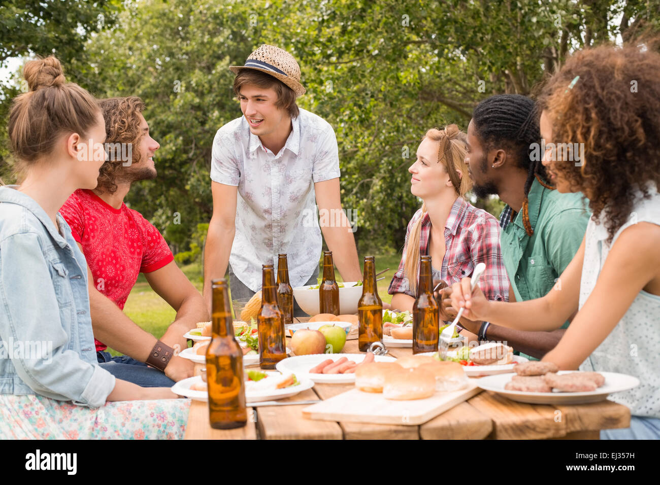 Happy friends in the park having lunch Stock Photo - Alamy