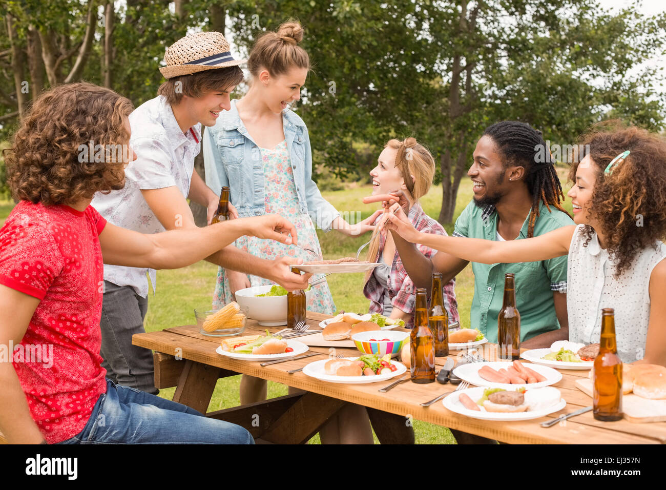Happy friends in the park having lunch Stock Photo - Alamy