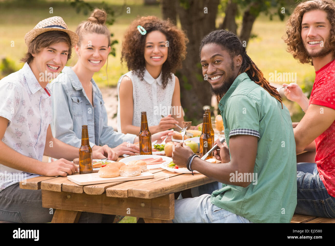Happy friends in the park having lunch Stock Photo - Alamy