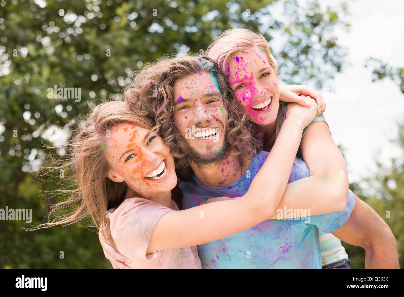 Happy friends covered in powder paint Stock Photo - Alamy