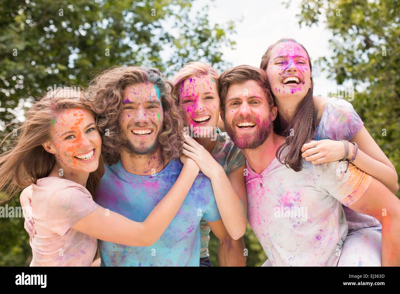 Happy friends covered in powder paint Stock Photo - Alamy