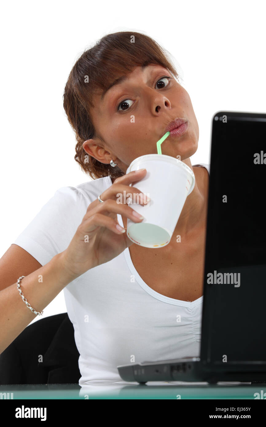 Woman drinking soft drink at desk Stock Photo - Alamy