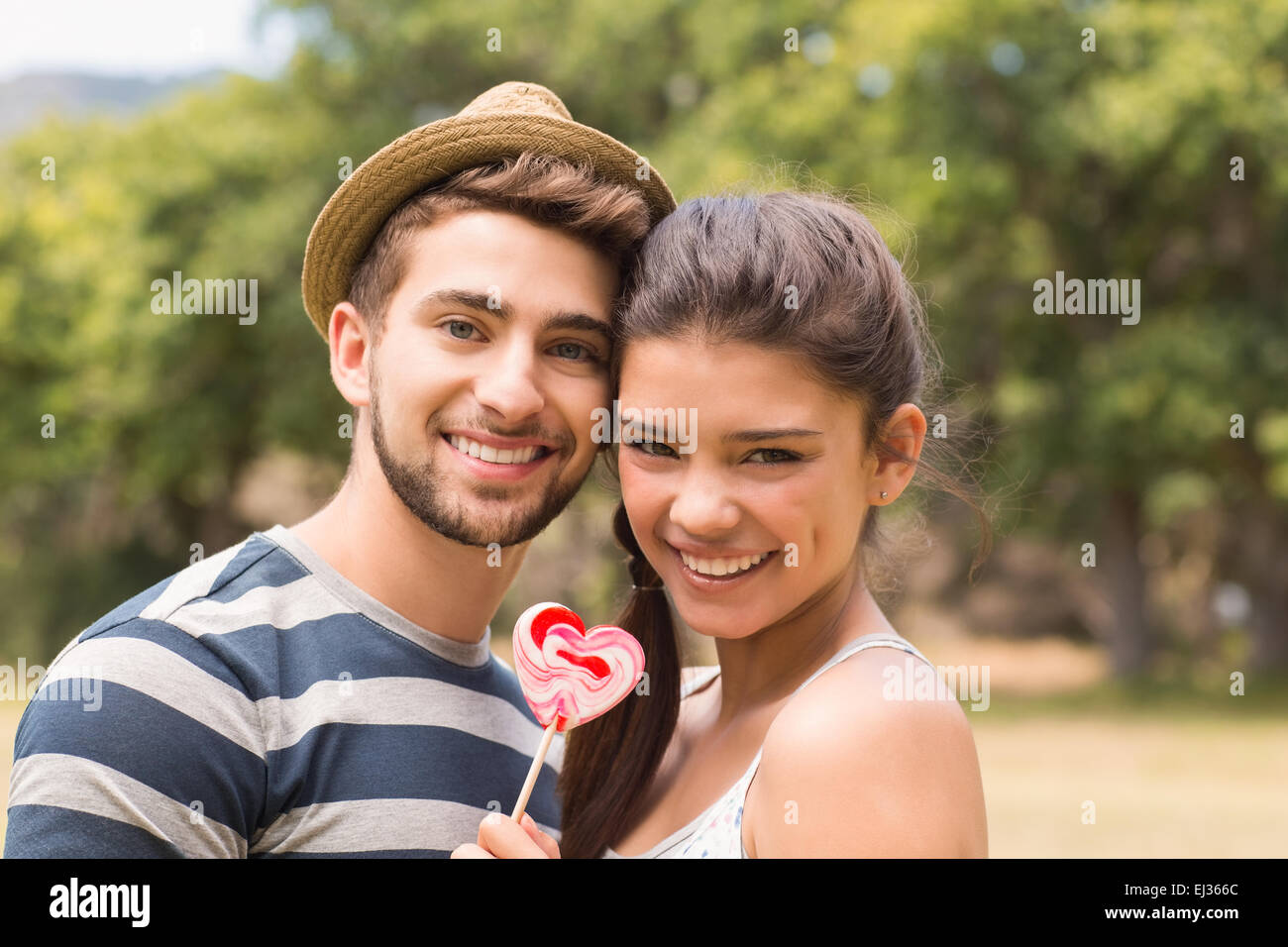 Cute couple sharing a lollipop Stock Photo - Alamy