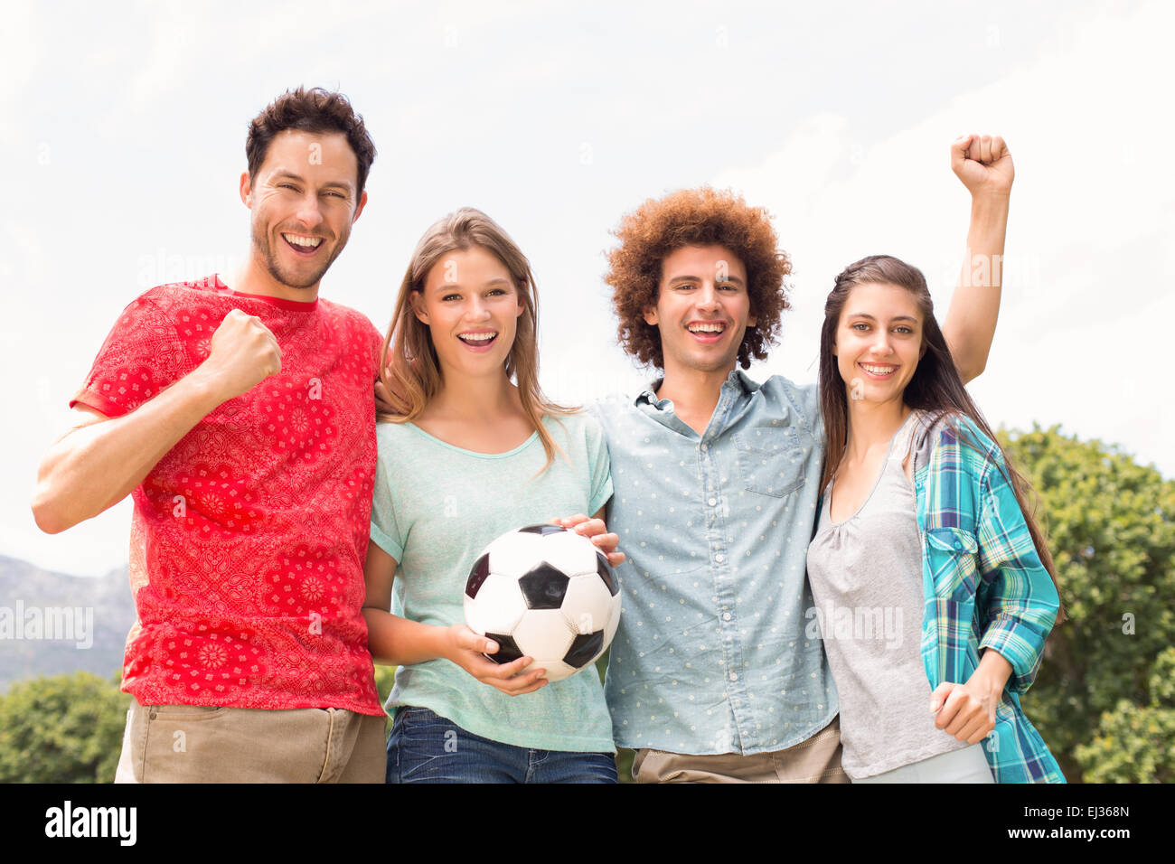 Happy friends in the park with football Stock Photo - Alamy