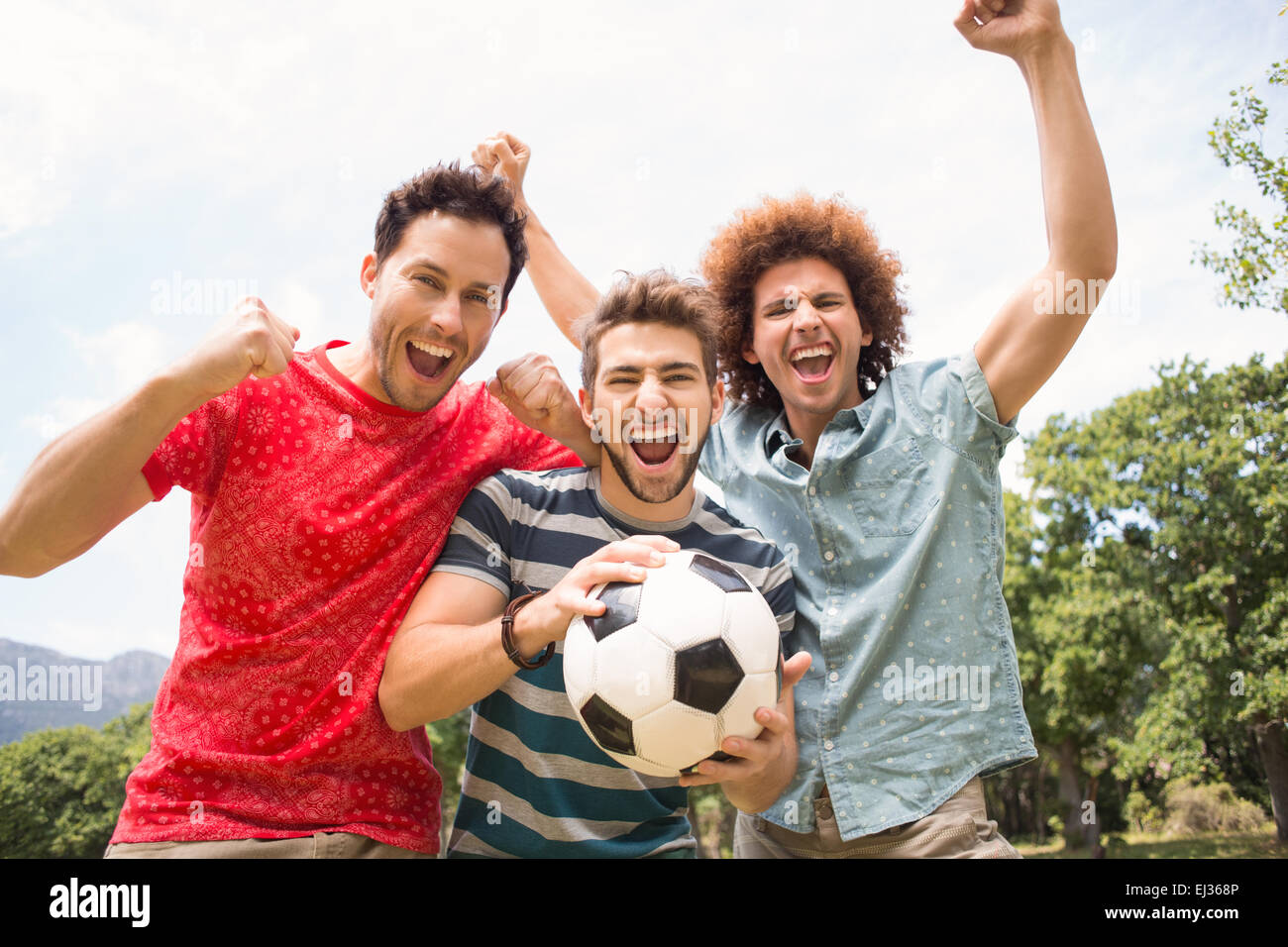 Happy friends in the park with football Stock Photo - Alamy