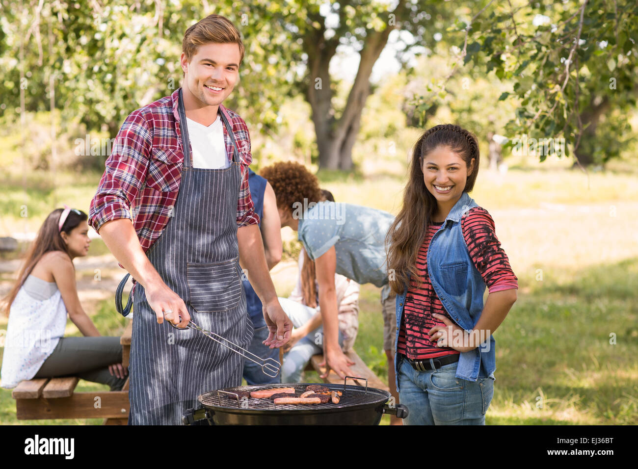 Happy friends in the park having barbecue Stock Photo - Alamy