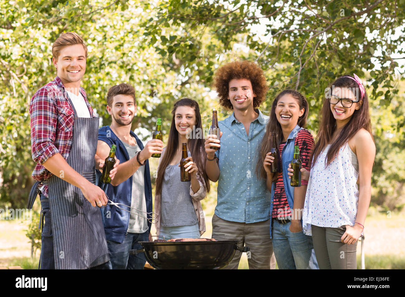 Happy friends in the park having barbecue Stock Photo - Alamy