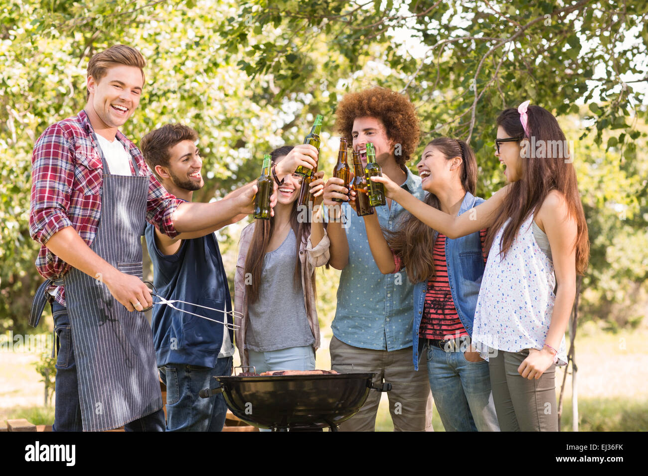 Happy friends in the park having barbecue Stock Photo - Alamy