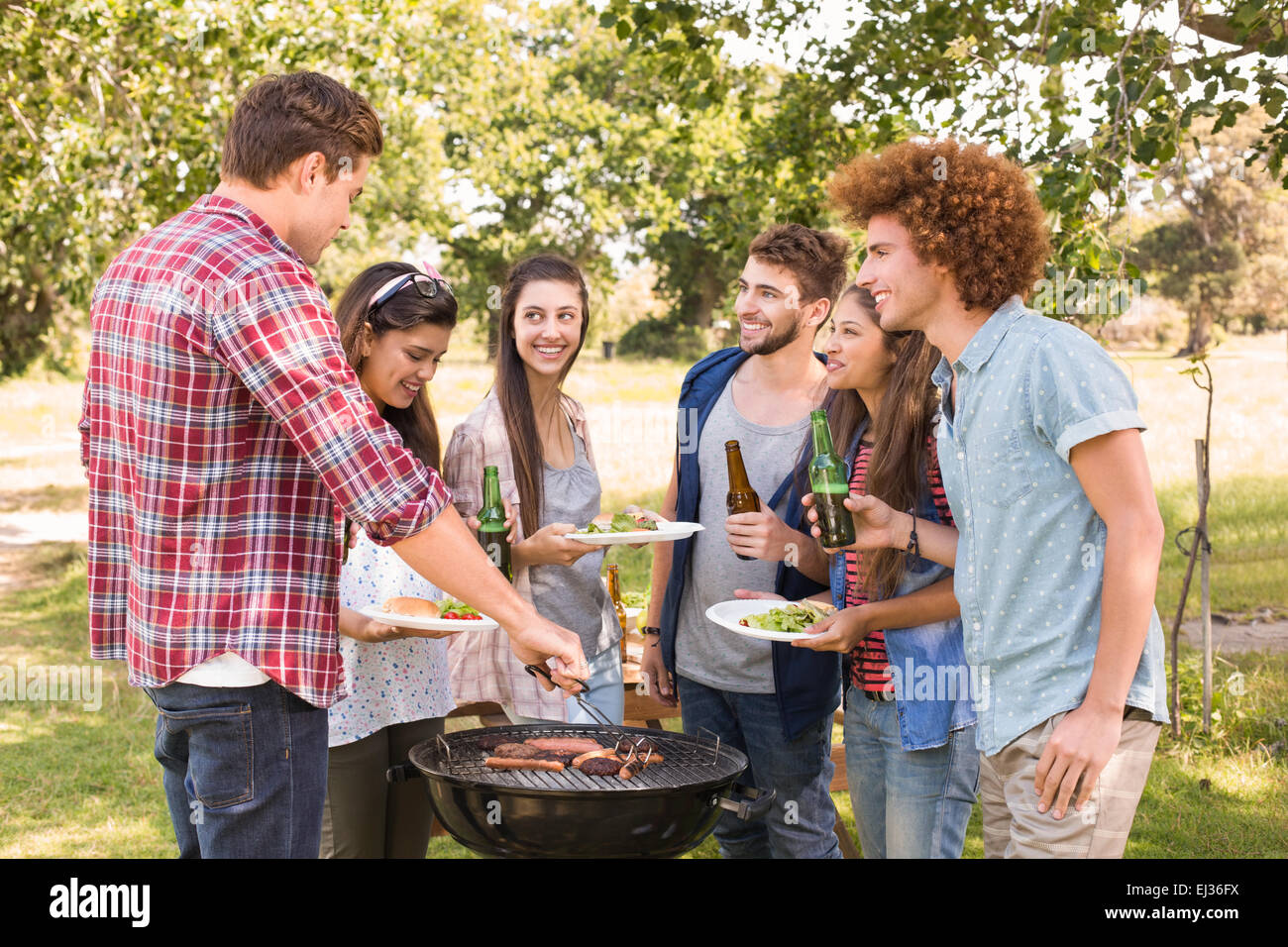 Happy friends in the park having barbecue Stock Photo - Alamy