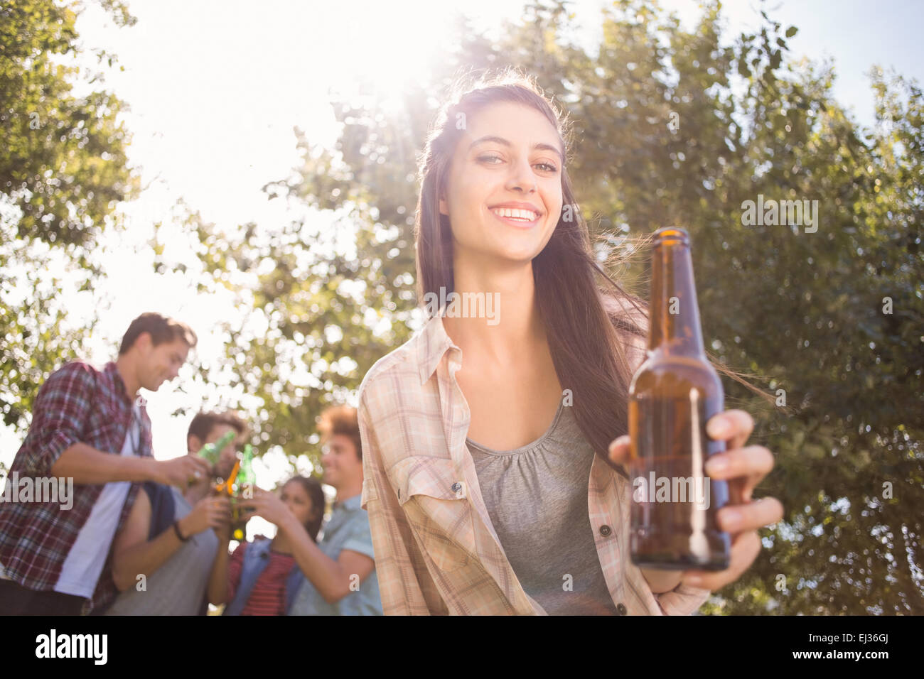 Happy friends in the park having beers Stock Photo - Alamy