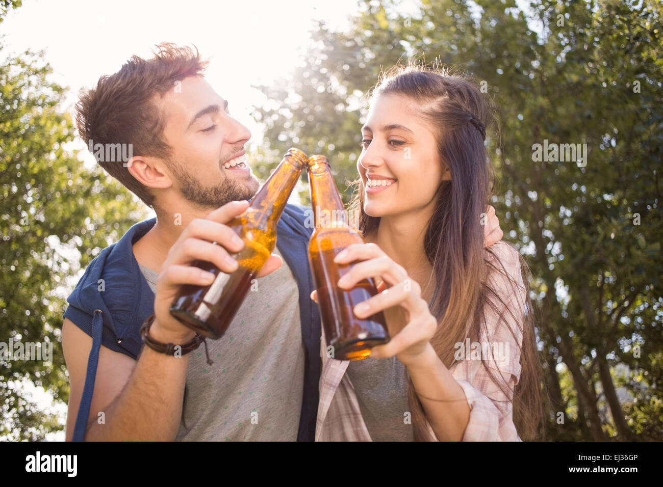 Happy friends in the park having beers Stock Photo - Alamy