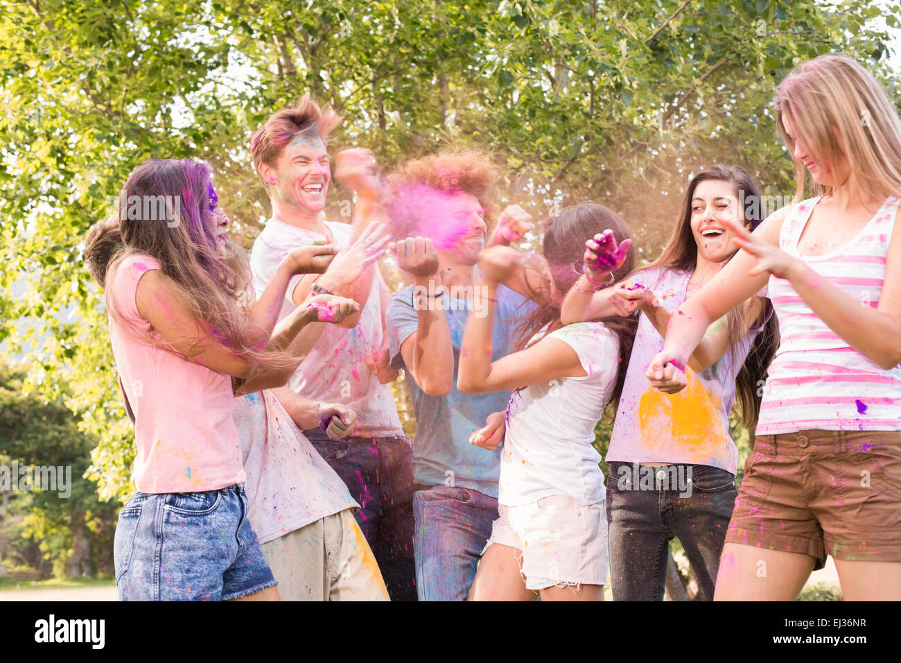 Happy friends covered in powder paint Stock Photo - Alamy