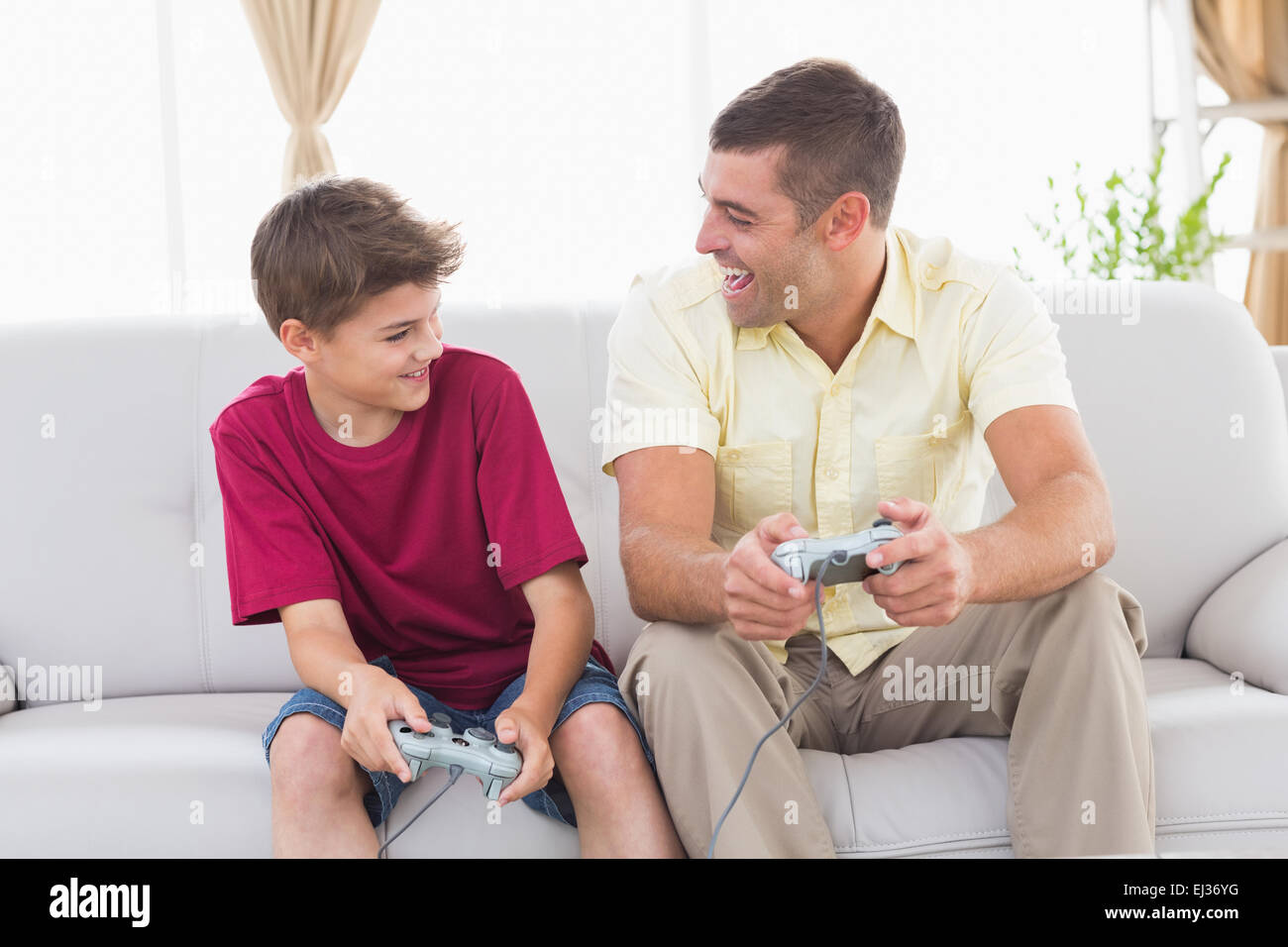 Father and son playing video game at home Stock Photo - Alamy