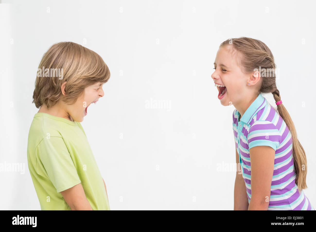 Siblings laughing on white background Stock Photo - Alamy
