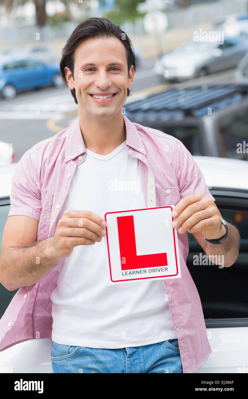 Learner driver smiling and holding l plate Stock Photo - Alamy