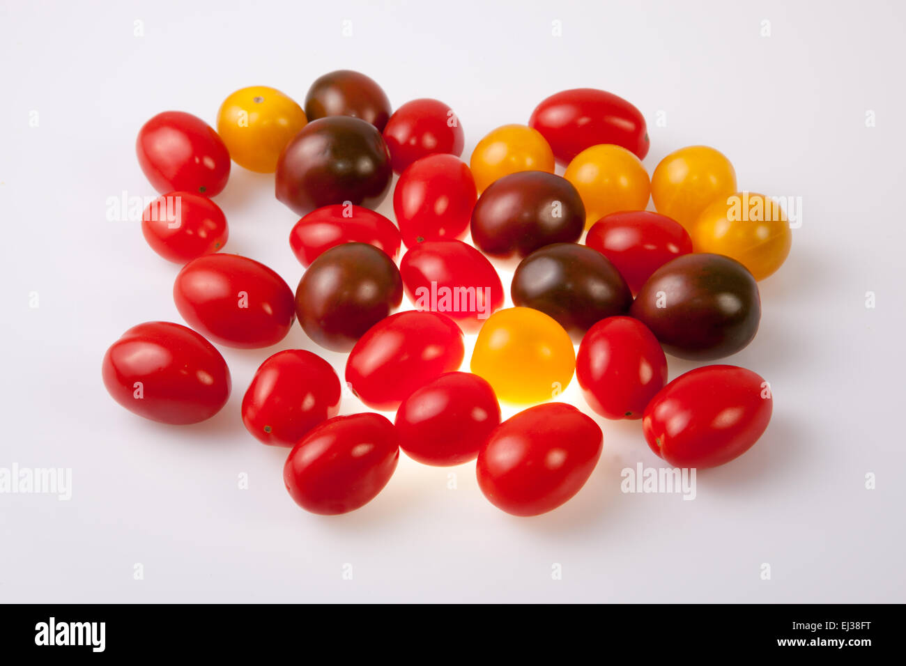 Handful of red shiny cherry tomatoes. Isolated over white background ...