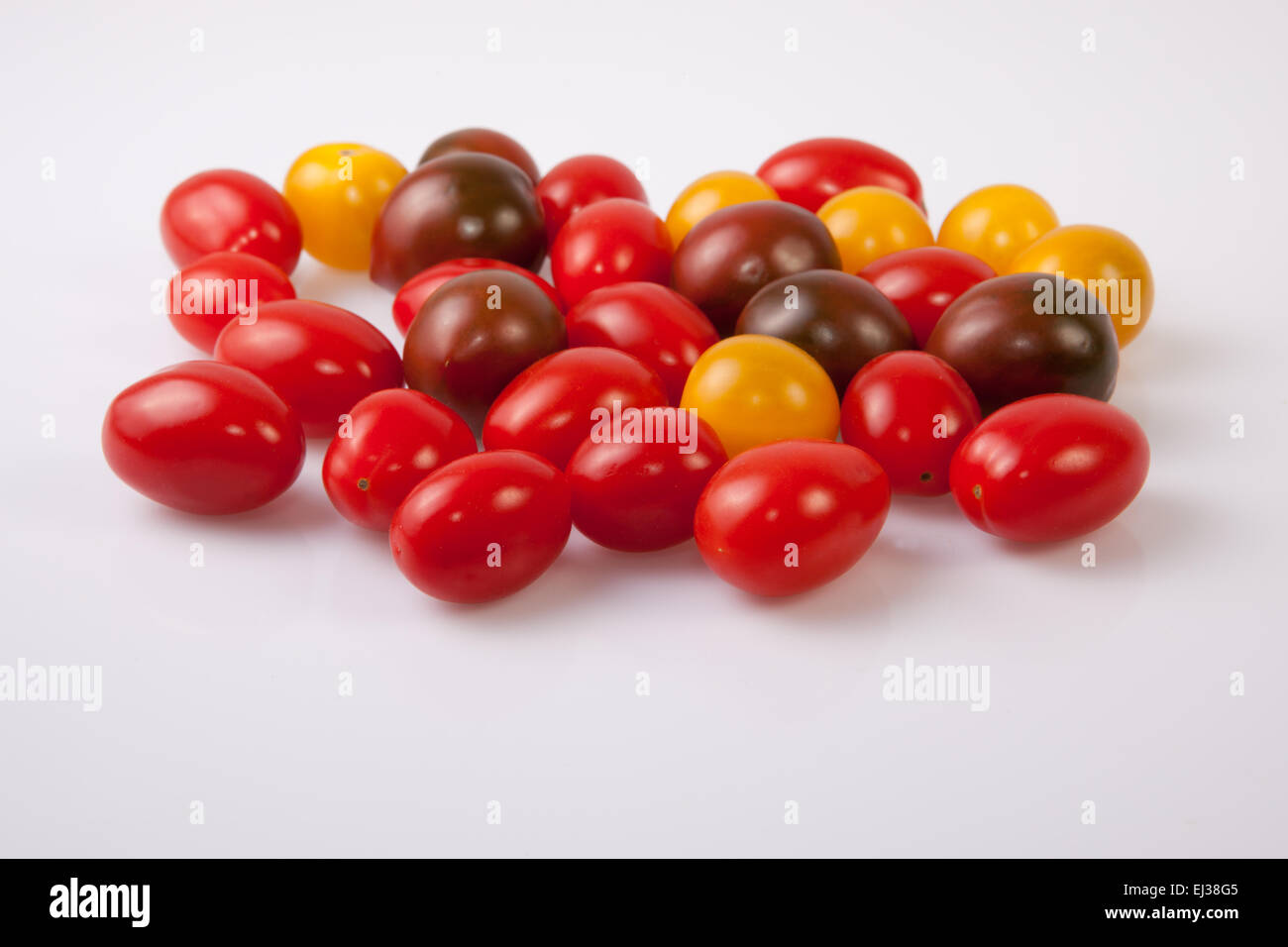 Handful of red shiny cherry tomatoes. Isolated over white background ...