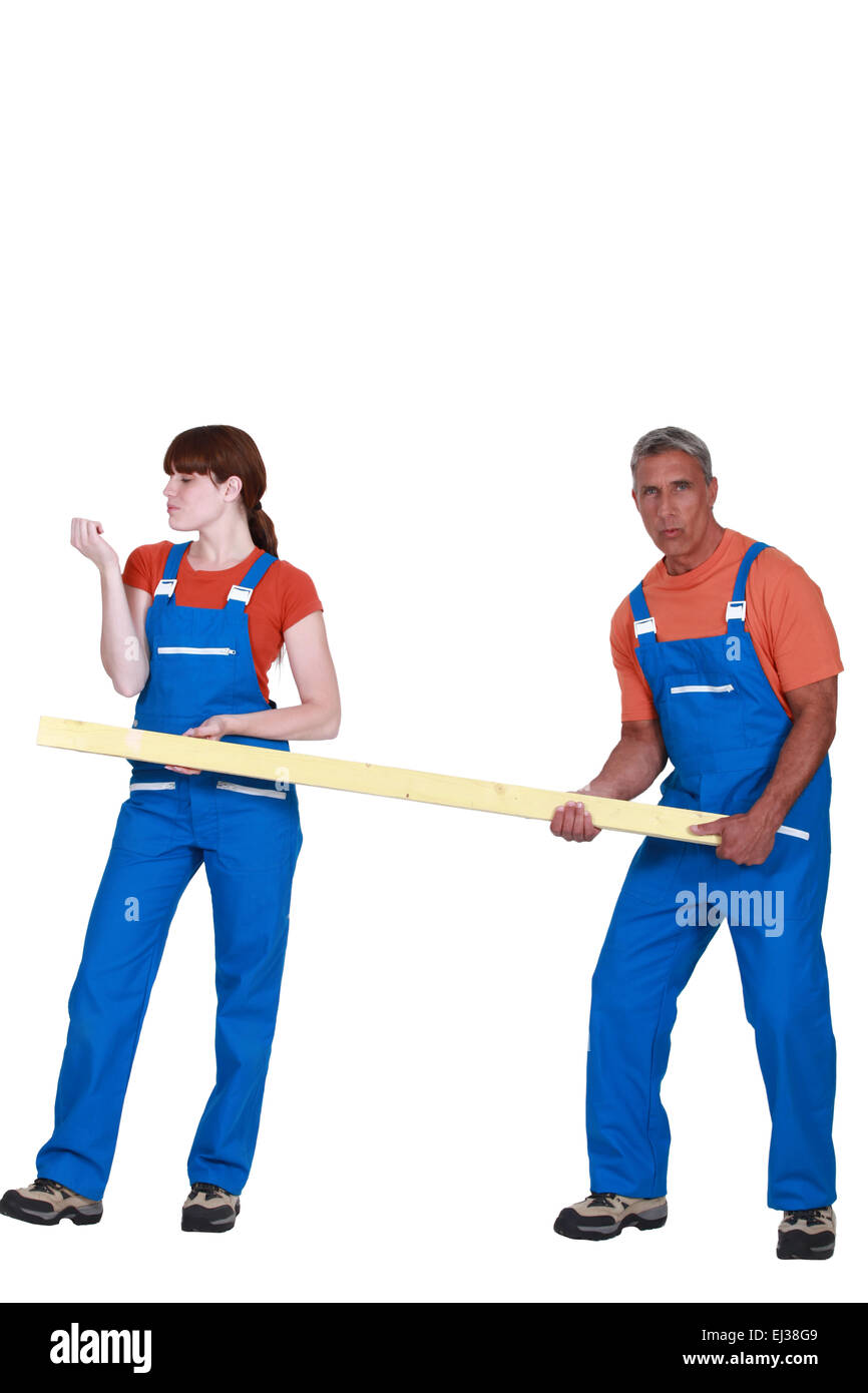 Construction couple carrying timber Stock Photo - Alamy