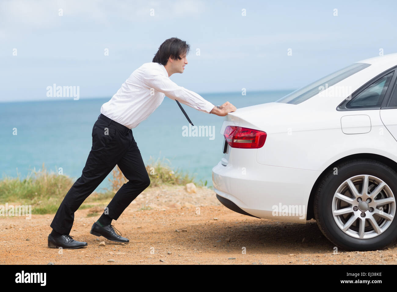 Businessman pushing his car Stock Photo - Alamy