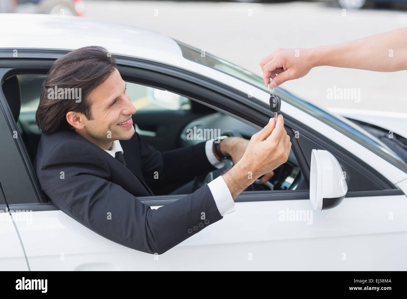 Businessman getting his new car key Stock Photo - Alamy