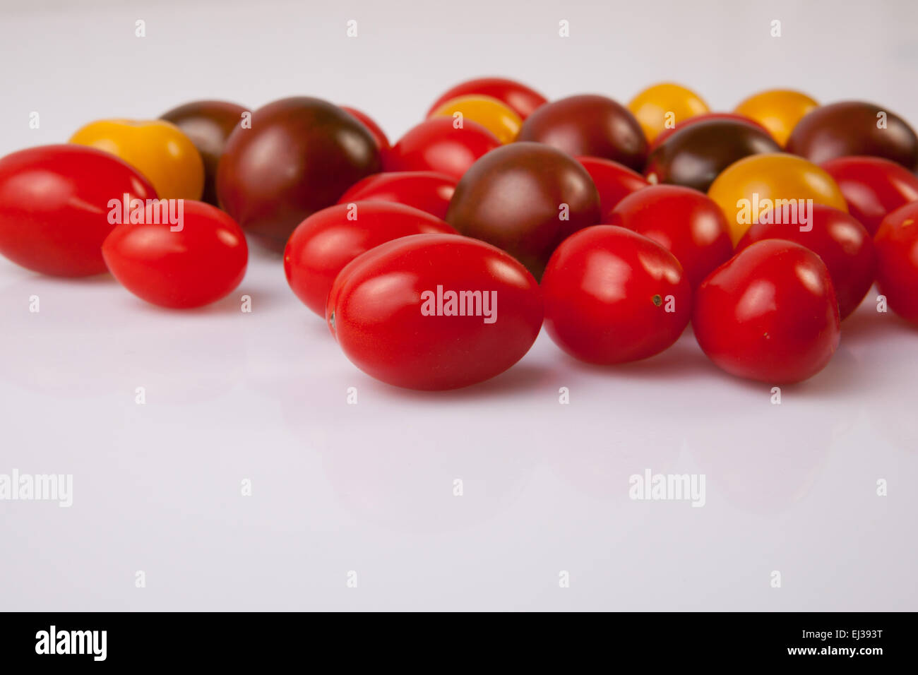Handful of red shiny cherry tomatoes. Isolated over white background ...
