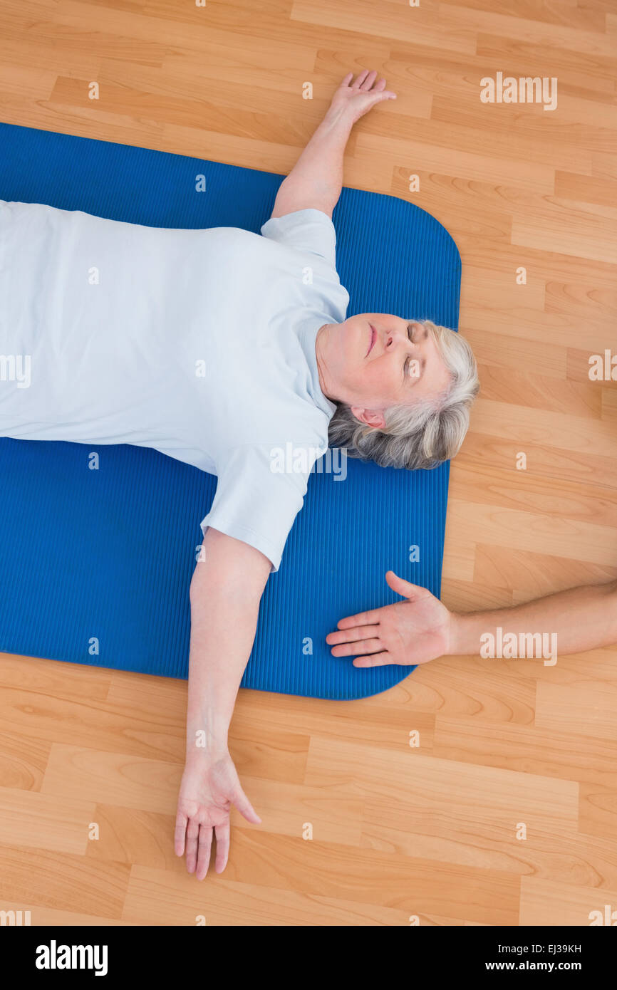 Senior woman lying on exercise mat Stock Photo - Alamy