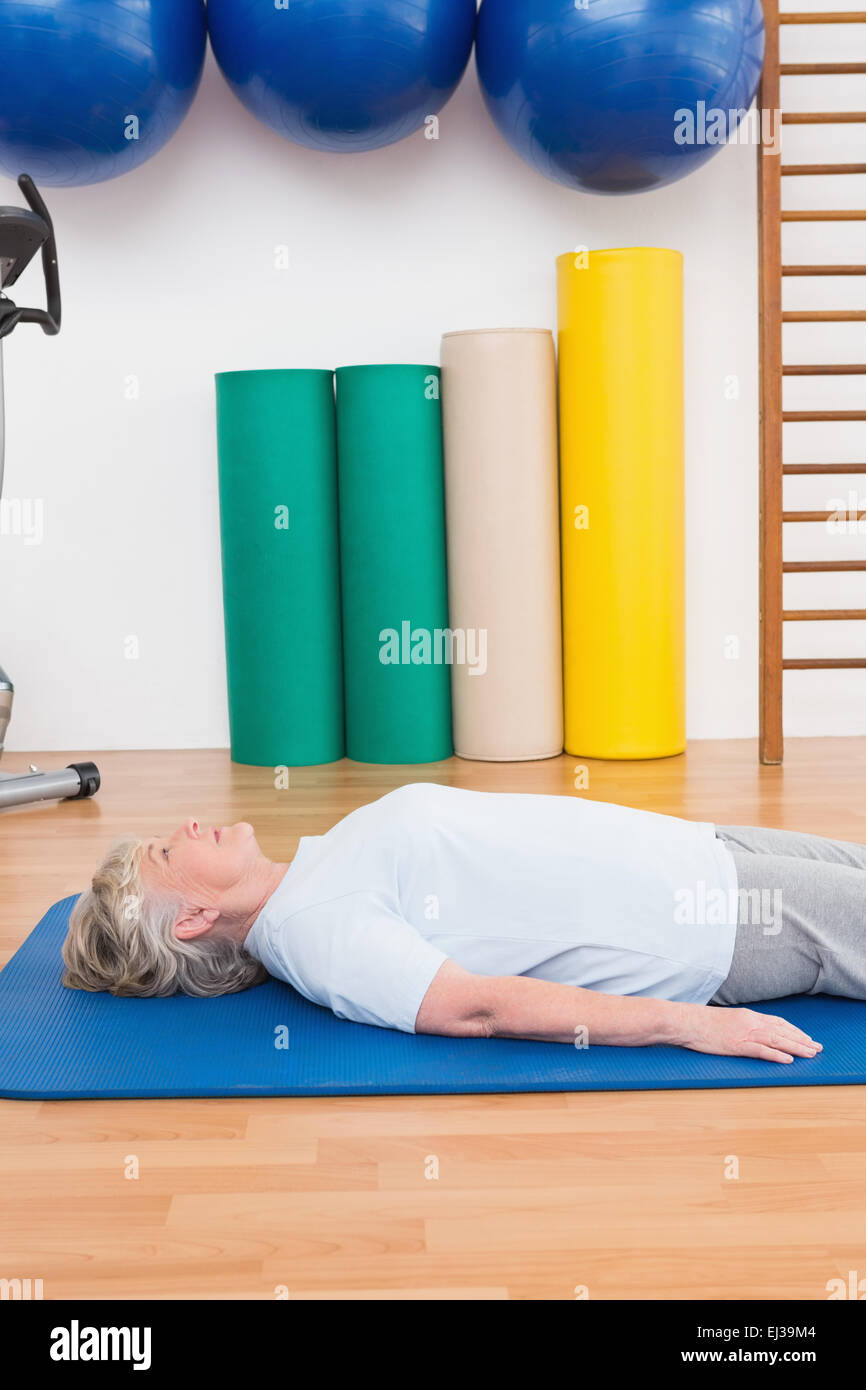 Senior woman lying on exercise mat Stock Photo - Alamy