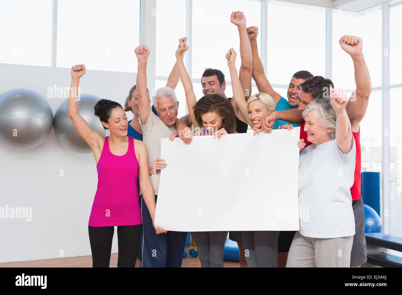 Cheerful friends holding blank together Stock Photo - Alamy