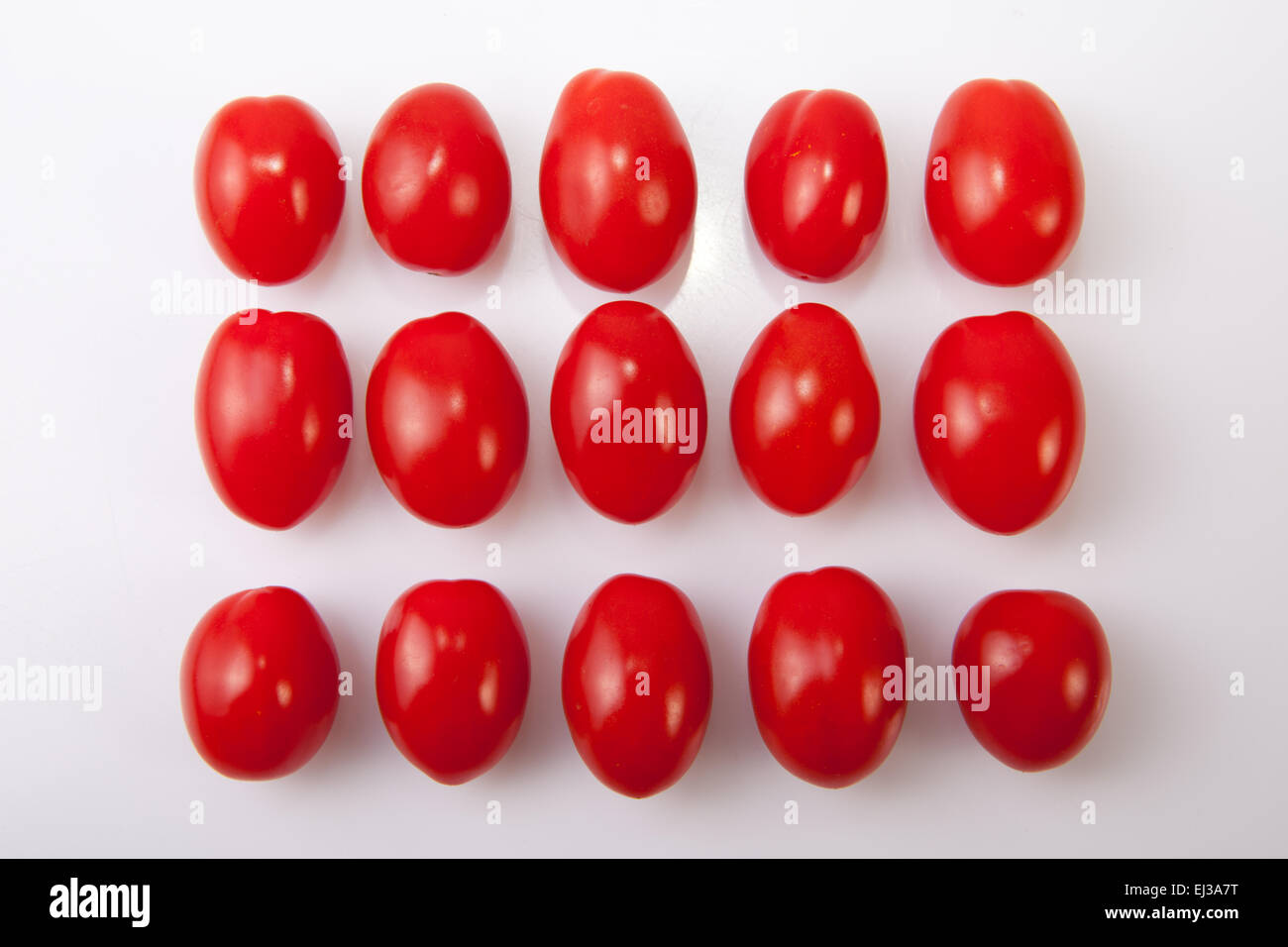 Handful of red shiny cherry tomatoes. Isolated over white background ...