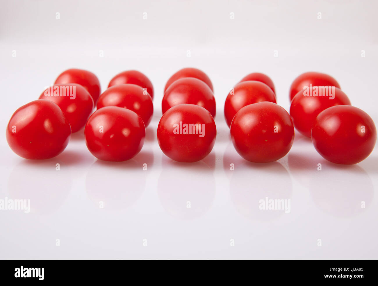 Handful of red shiny cherry tomatoes. Isolated over white background ...