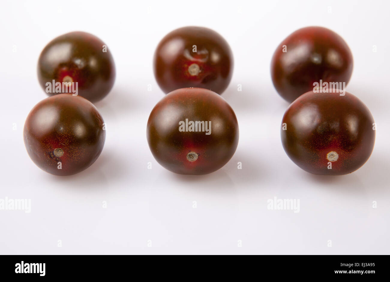 Handful of red shiny cherry tomatoes. Isolated over white background ...