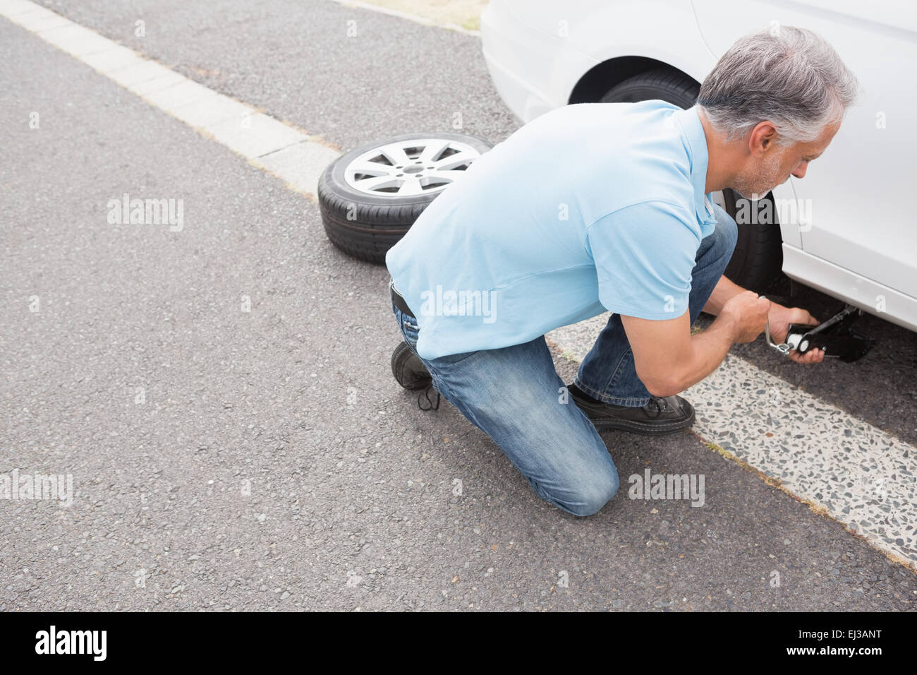 Man fixing tire Stock Photo - Alamy