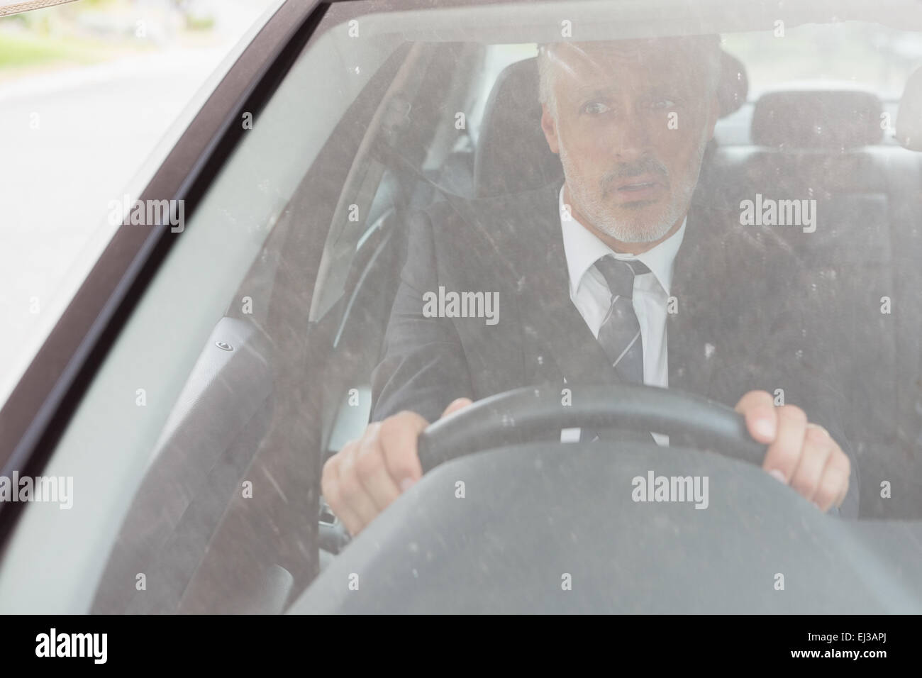 Perplexed man sitting at the wheel Stock Photo - Alamy
