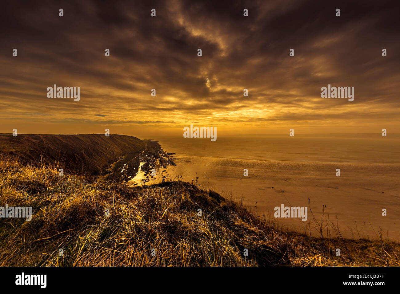 Sun rising at Filey Brigg, Yorkshire, UK Stock Photo - Alamy