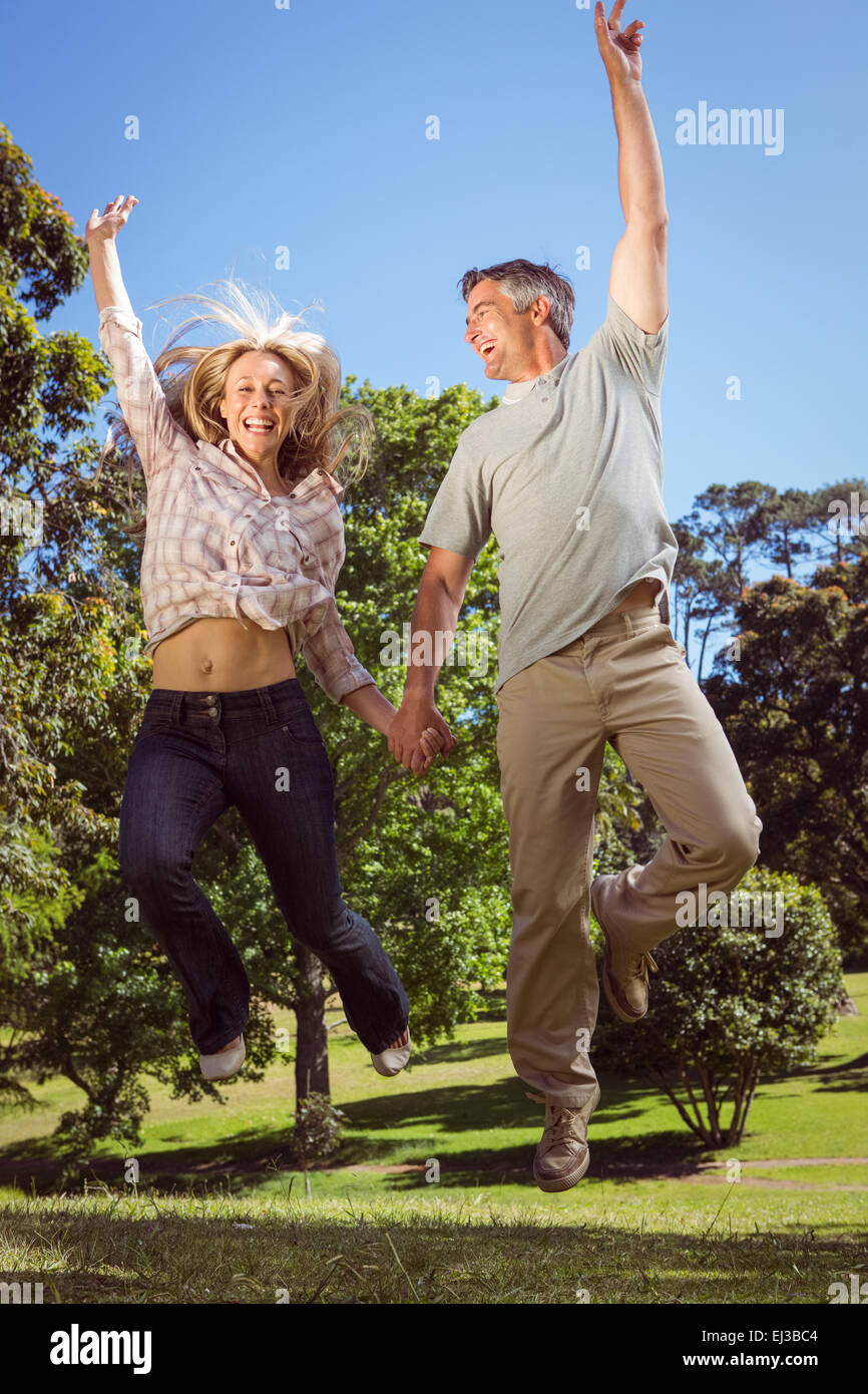 Happy couple jumping in the park Stock Photo - Alamy