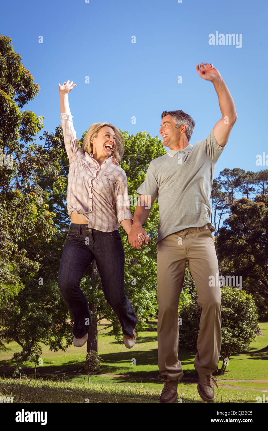 Happy couple jumping in the park Stock Photo - Alamy