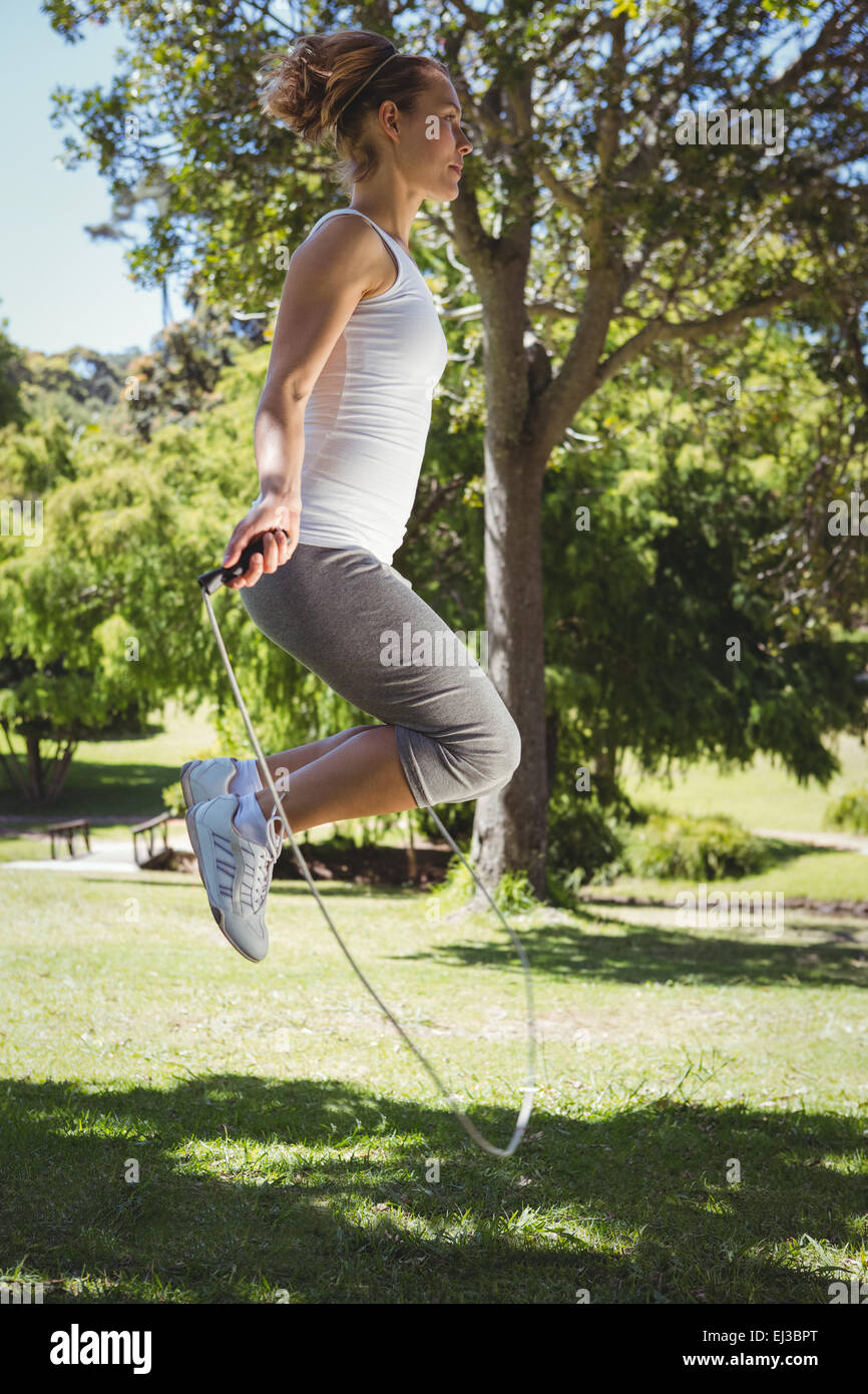 Fit woman skipping in the park Stock Photo - Alamy