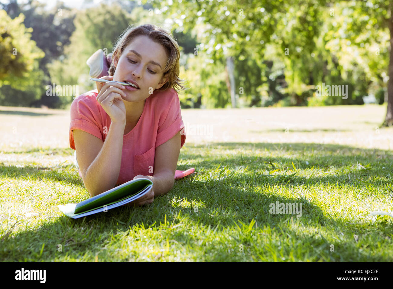 Pretty woman reading book in park Stock Photo - Alamy