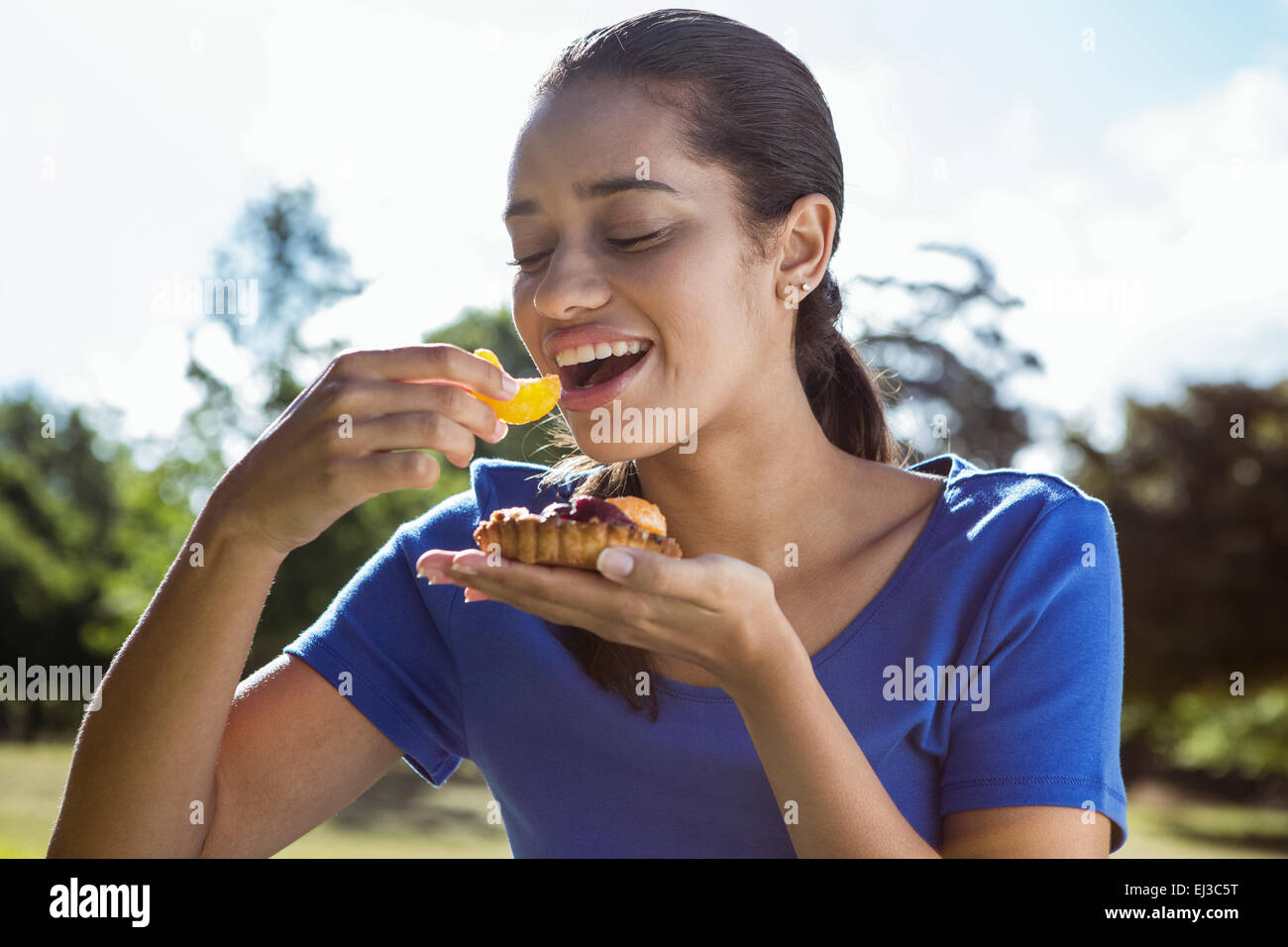 Pretty woman eating pizza in the park Stock Photo - Alamy